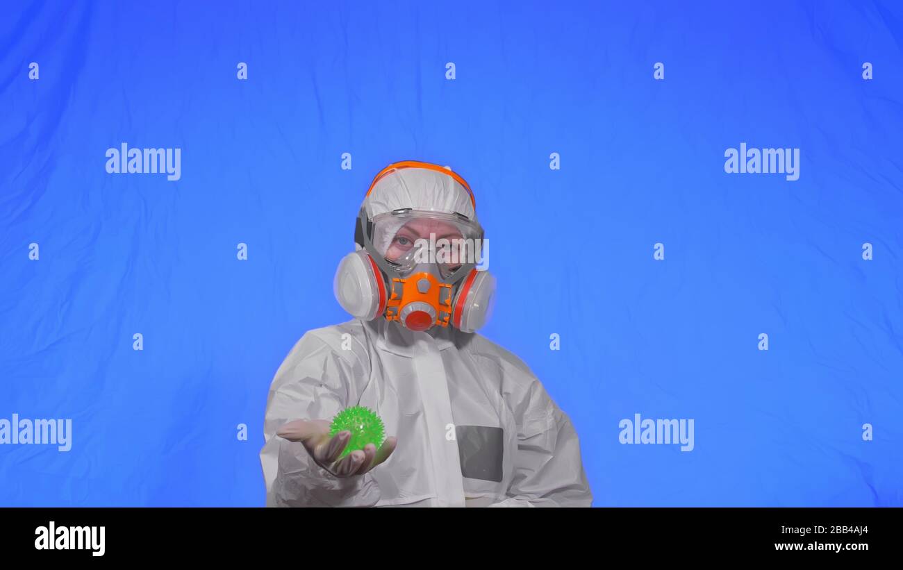 Doctor in respirator show a virus model. Slow motion. Woman wearing ...