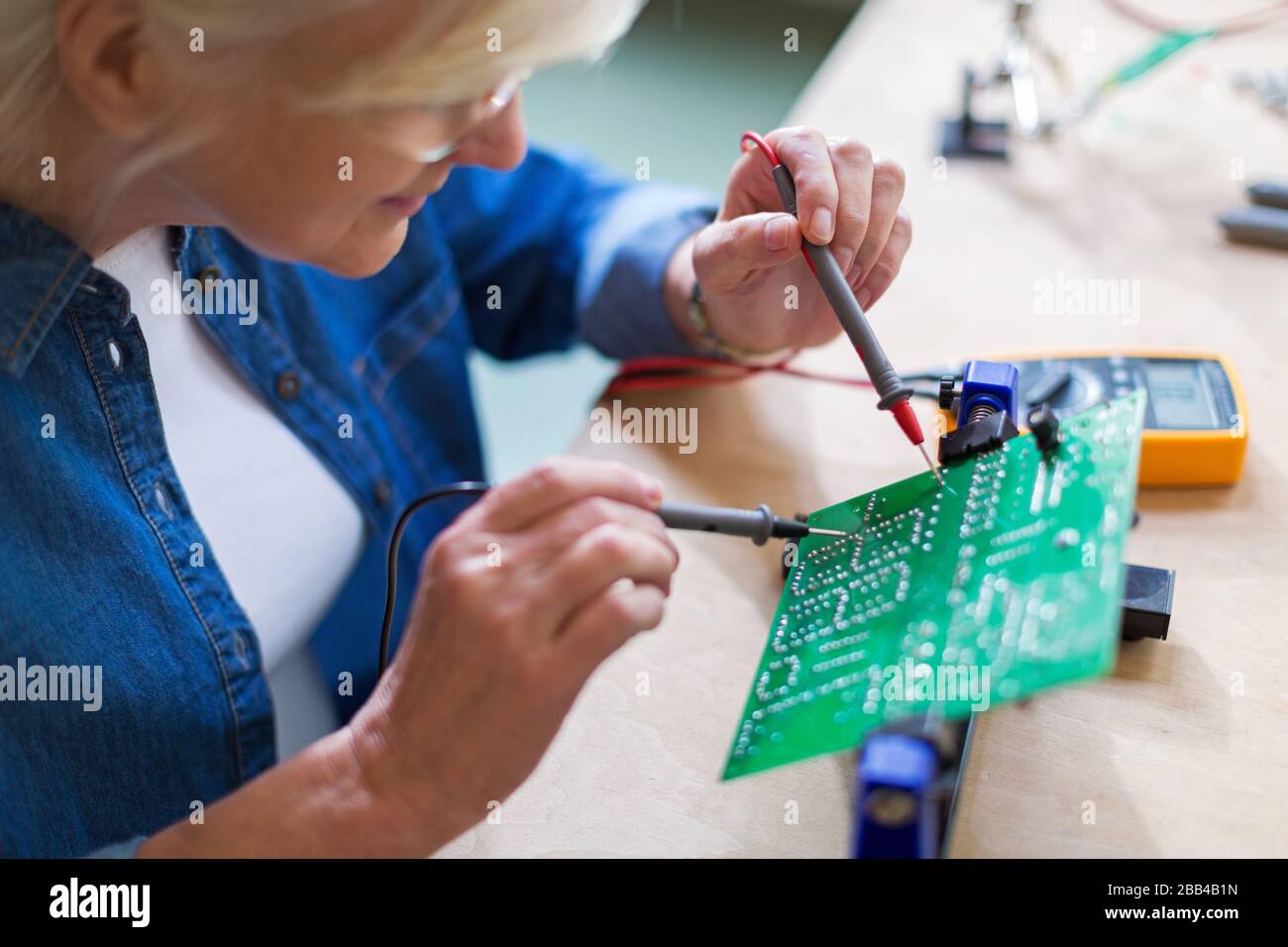 Senior woman in electronics workshop Stock Photo - Alamy