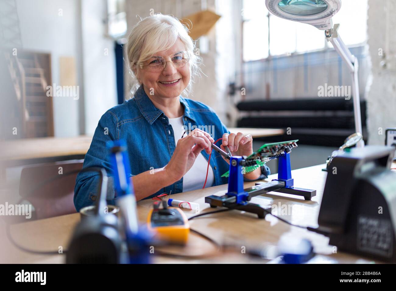 Senior woman in electronics workshop Stock Photo - Alamy