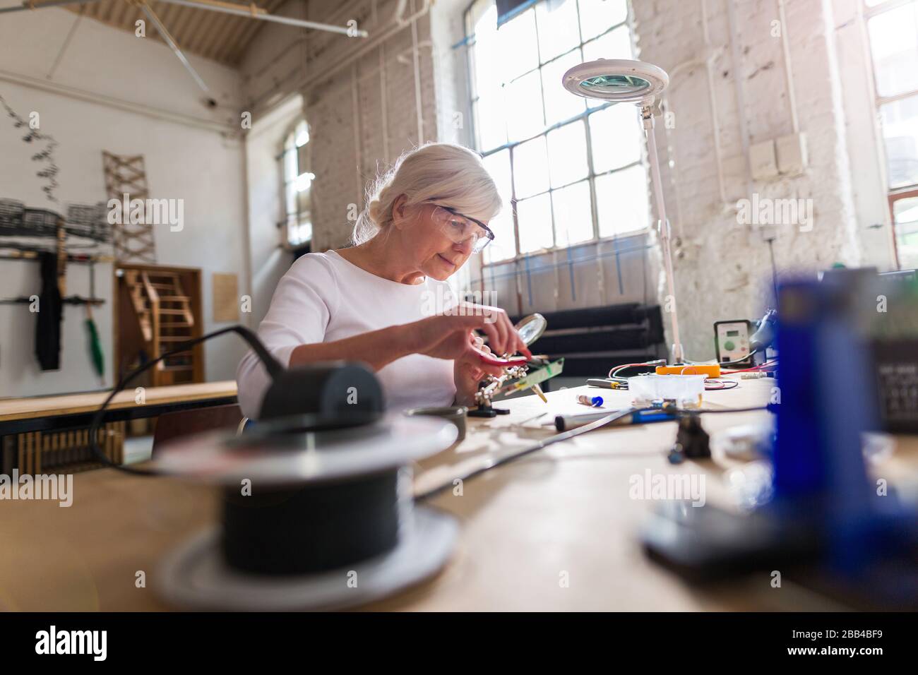 Senior woman in electronics workshop Stock Photo - Alamy