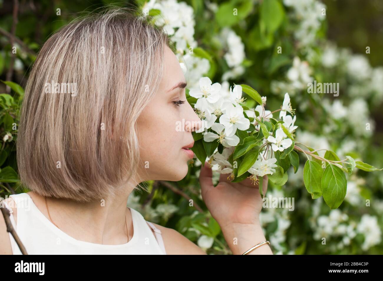 Young woman smelling flowers outdoor Stock Photo - Alamy