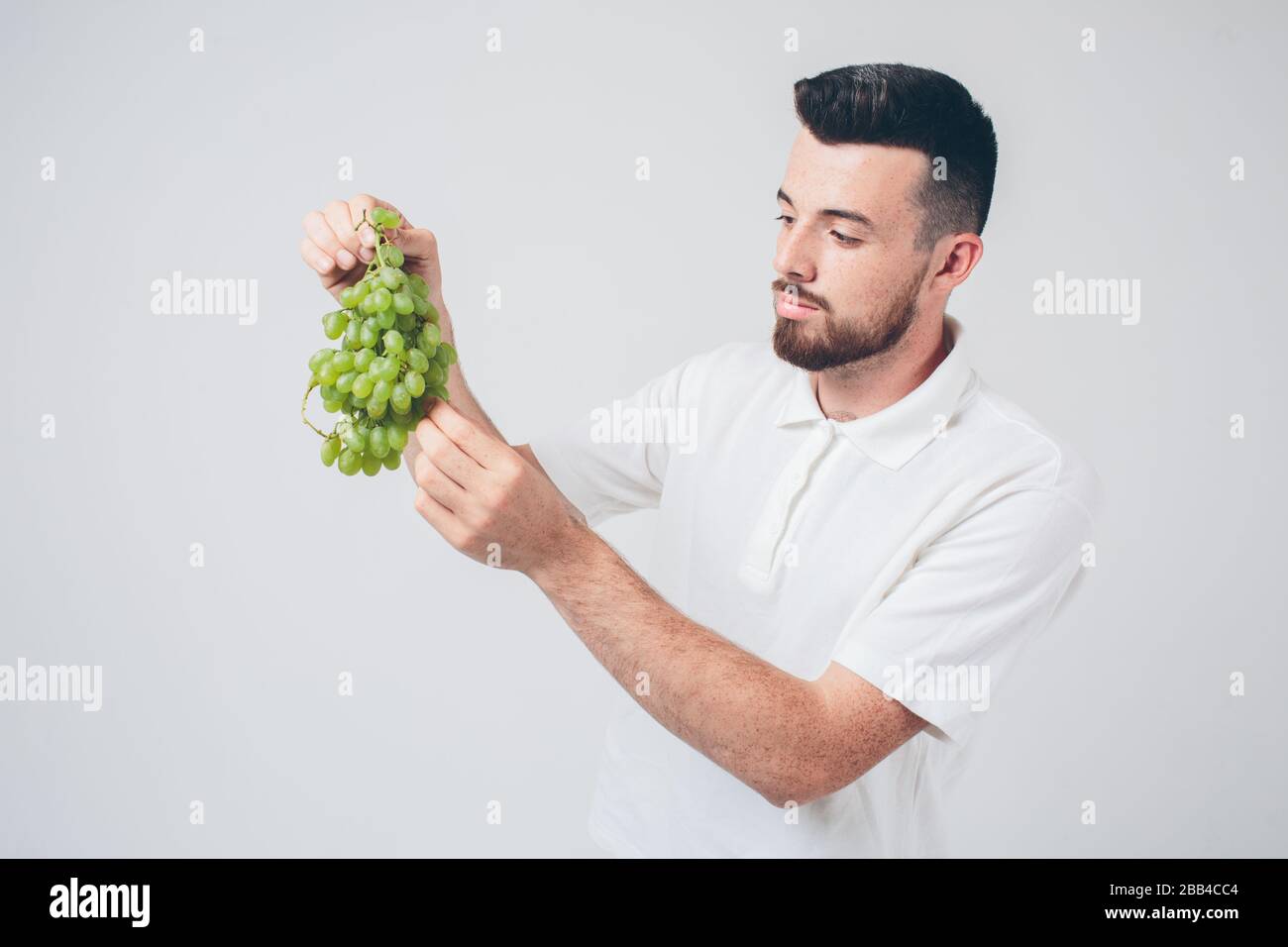 man holding grape, close up. concept. isolated on white Stock Photo - Alamy