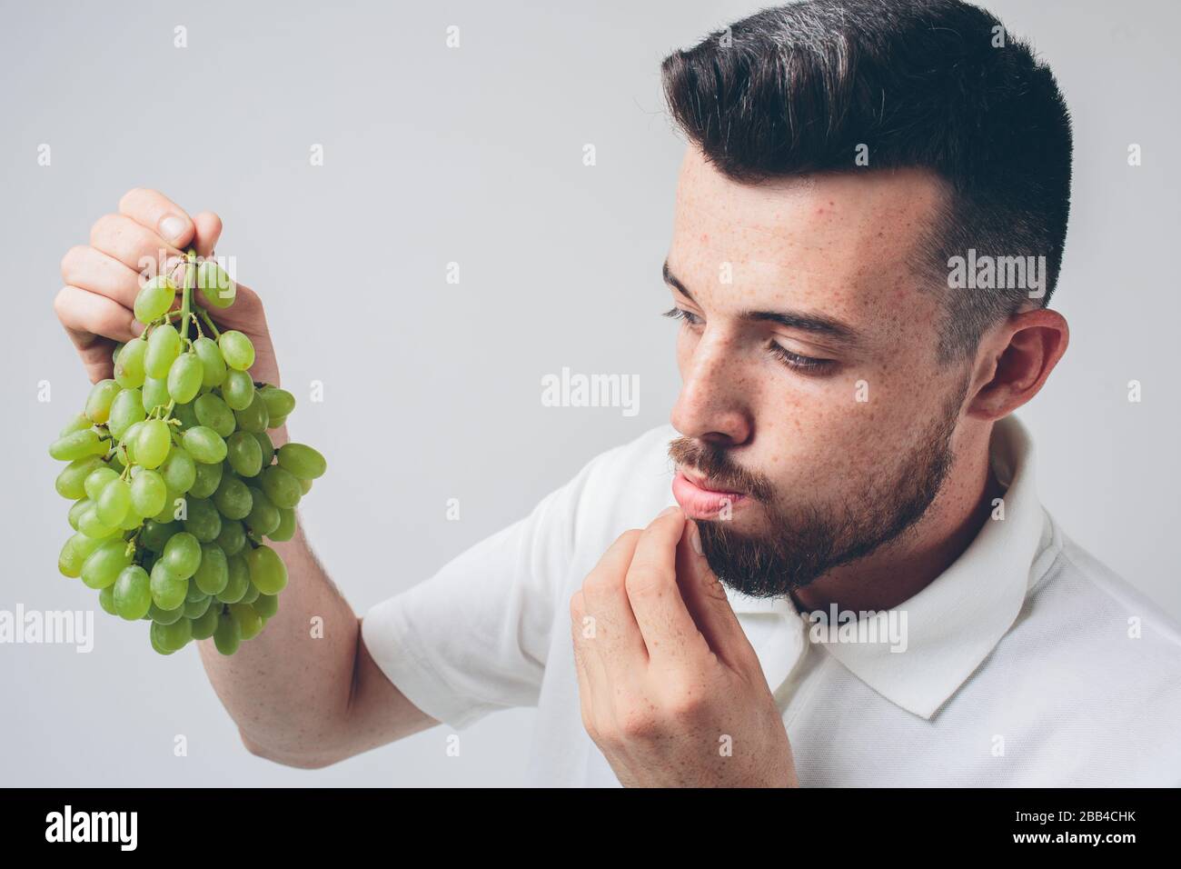 man holding grape, close up. concept. isolated on white Stock Photo - Alamy