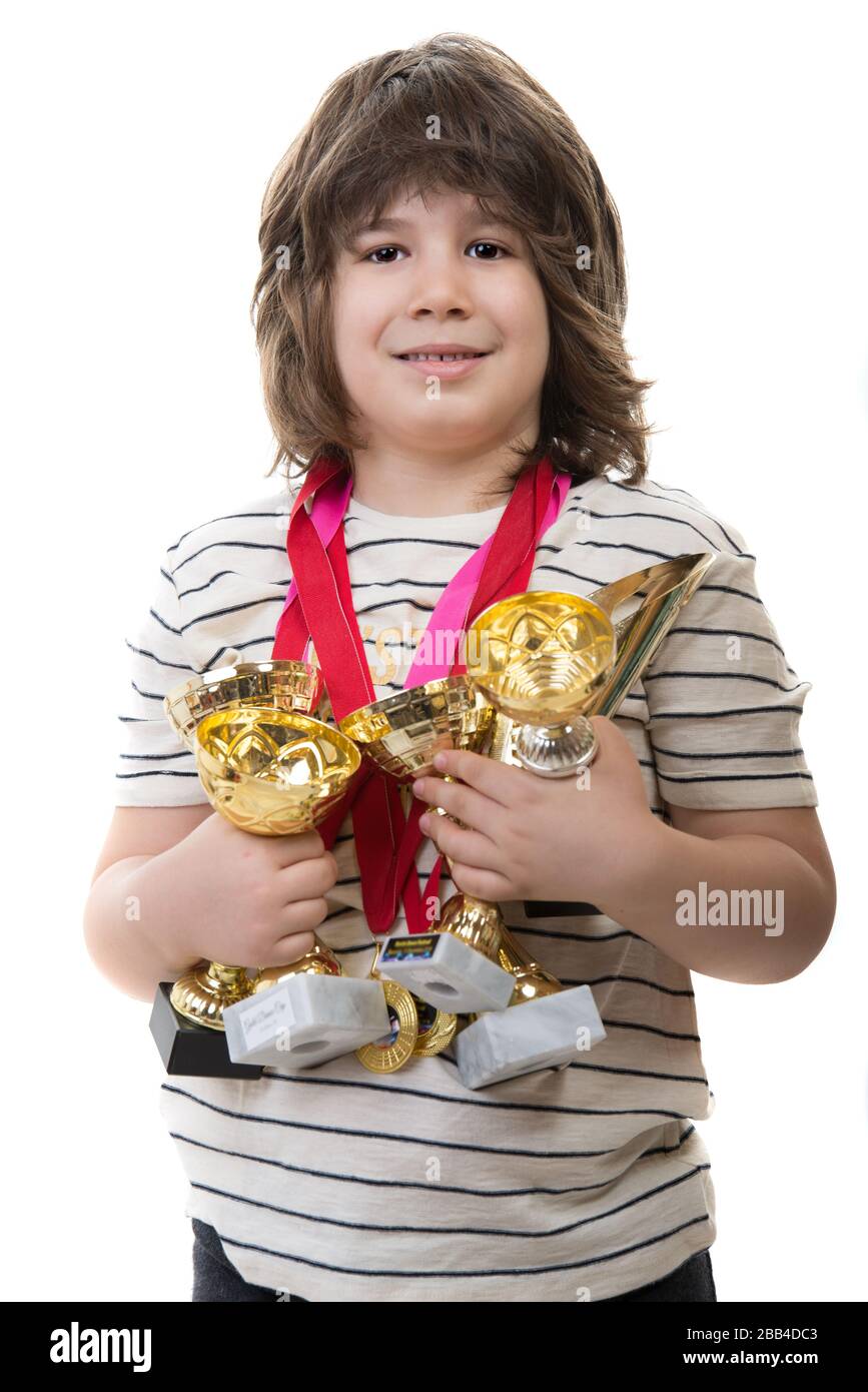 Successful kid boy holding many trophies and medals isolated on white ...