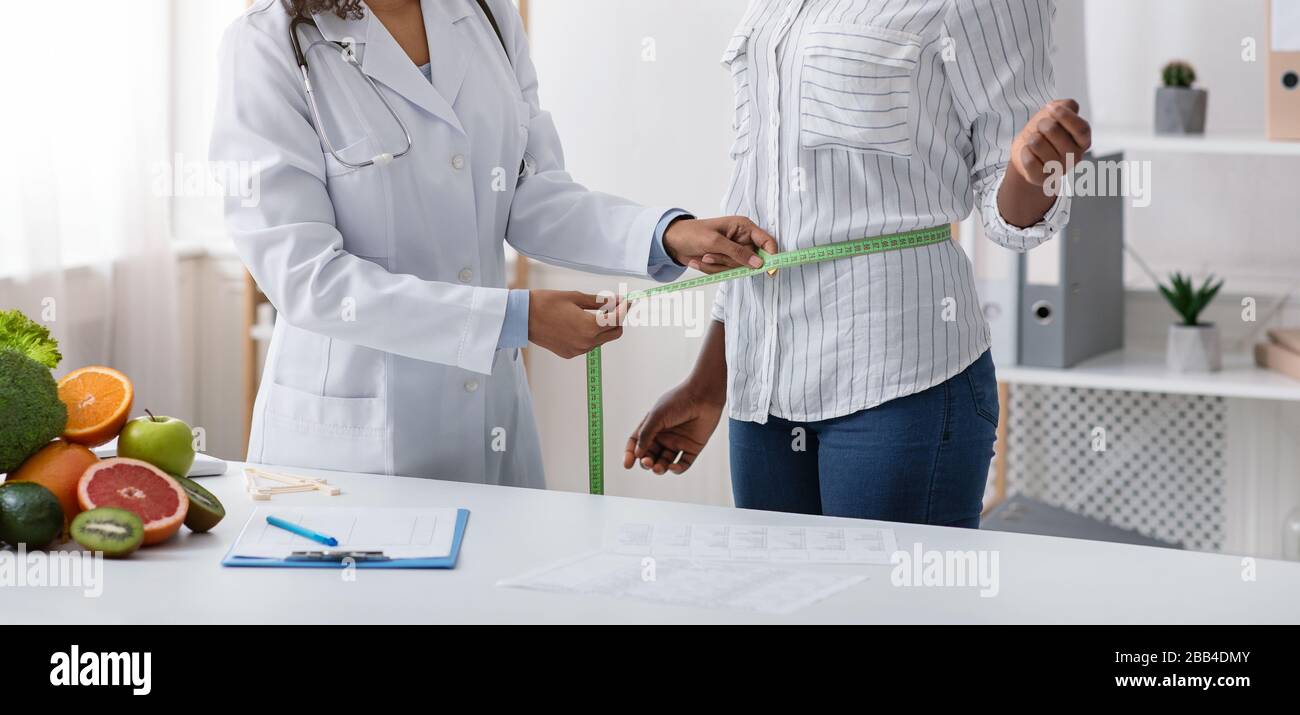 Cropped of doctor measuring patient body with tape Stock Photo - Alamy