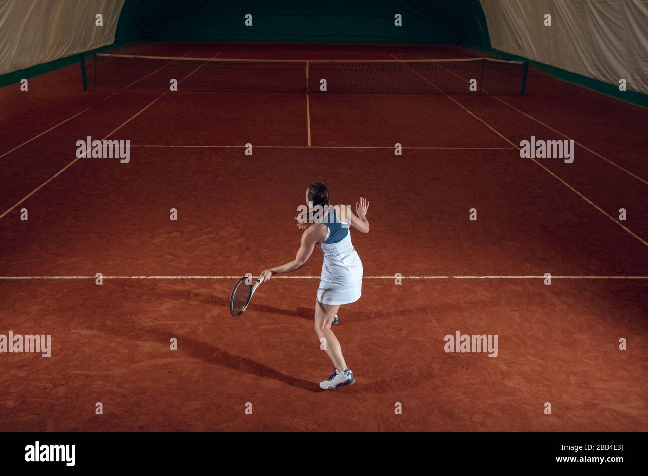 Young caucasian professional sportswoman playing tennis on sport court ...
