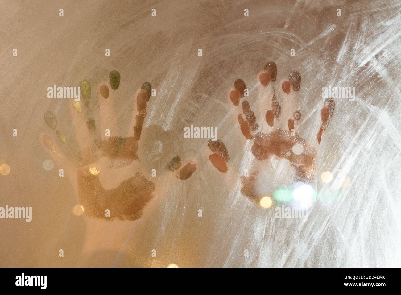Two hand prints of child kid in condensation on window pane at night ...