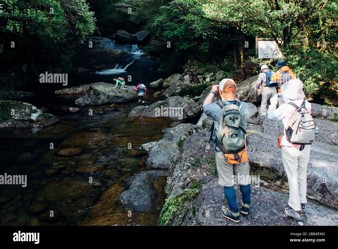 Children play on rocks while grandparents take pictures in Yakushima ...