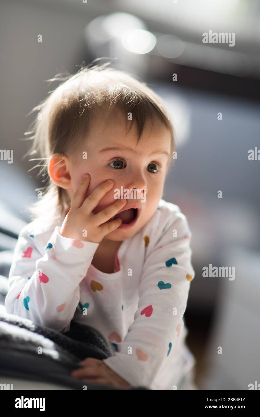 Adorable baby with funny expression indoors. Portrait of 1 year old ...