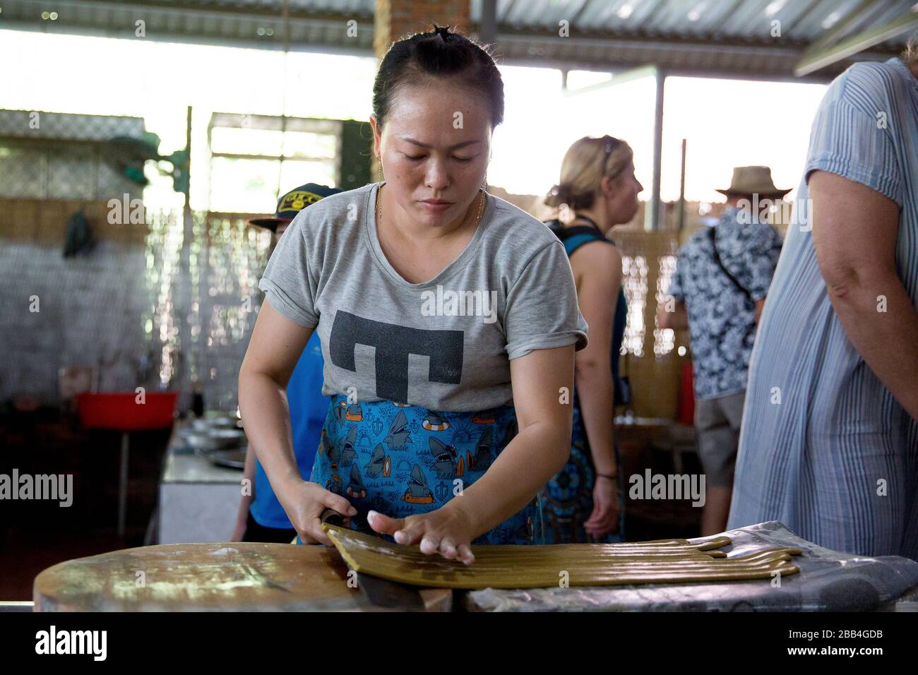A Vietnamese woman making coconut candy Stock Photo - Alamy