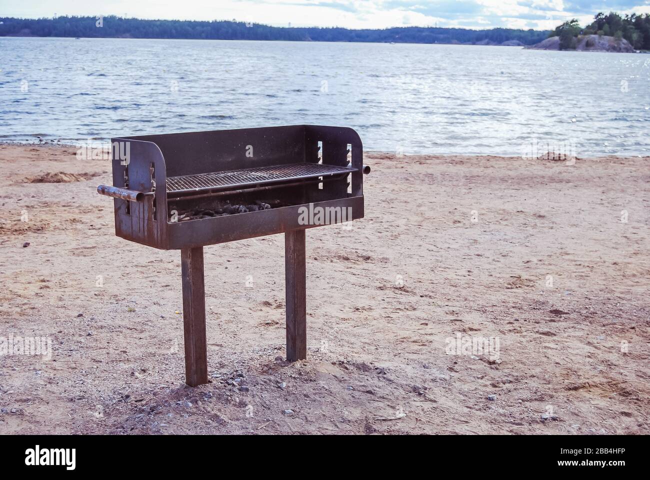 Barbecue planch on a beautiful sand beach next to a lake in Sweden ...