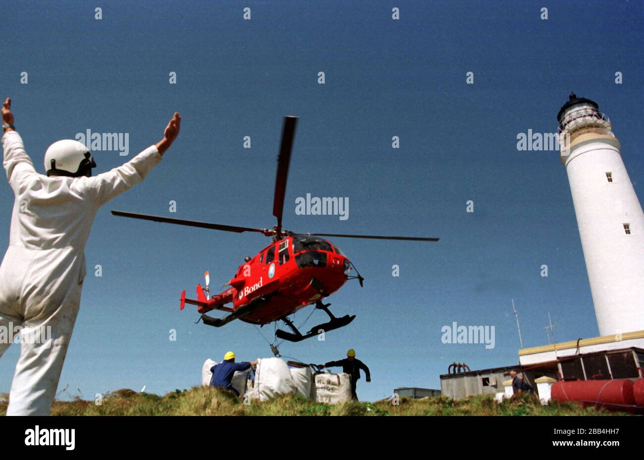 A supply helicopter flies over the lighthouse on the uninhabited island ...