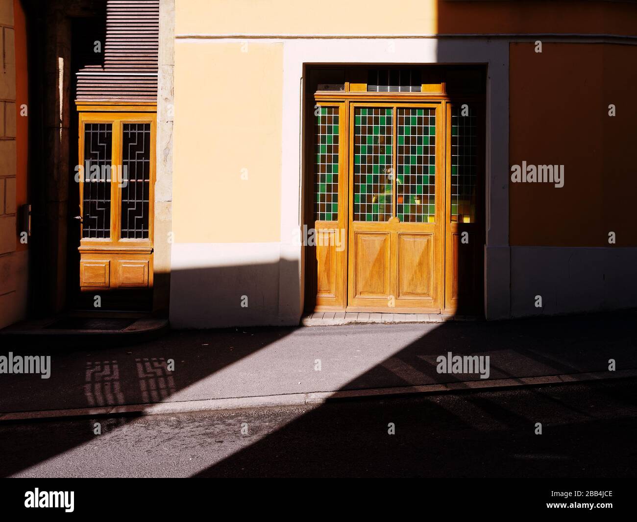 Vintage colourful stained glass wooden door lit by strong sunlight ...