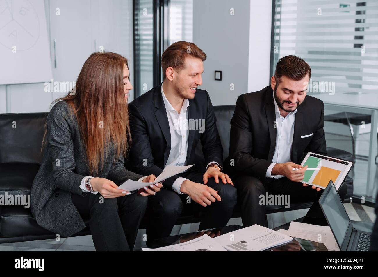 group of workers sitting at table in meeting room and sharing ideas ...
