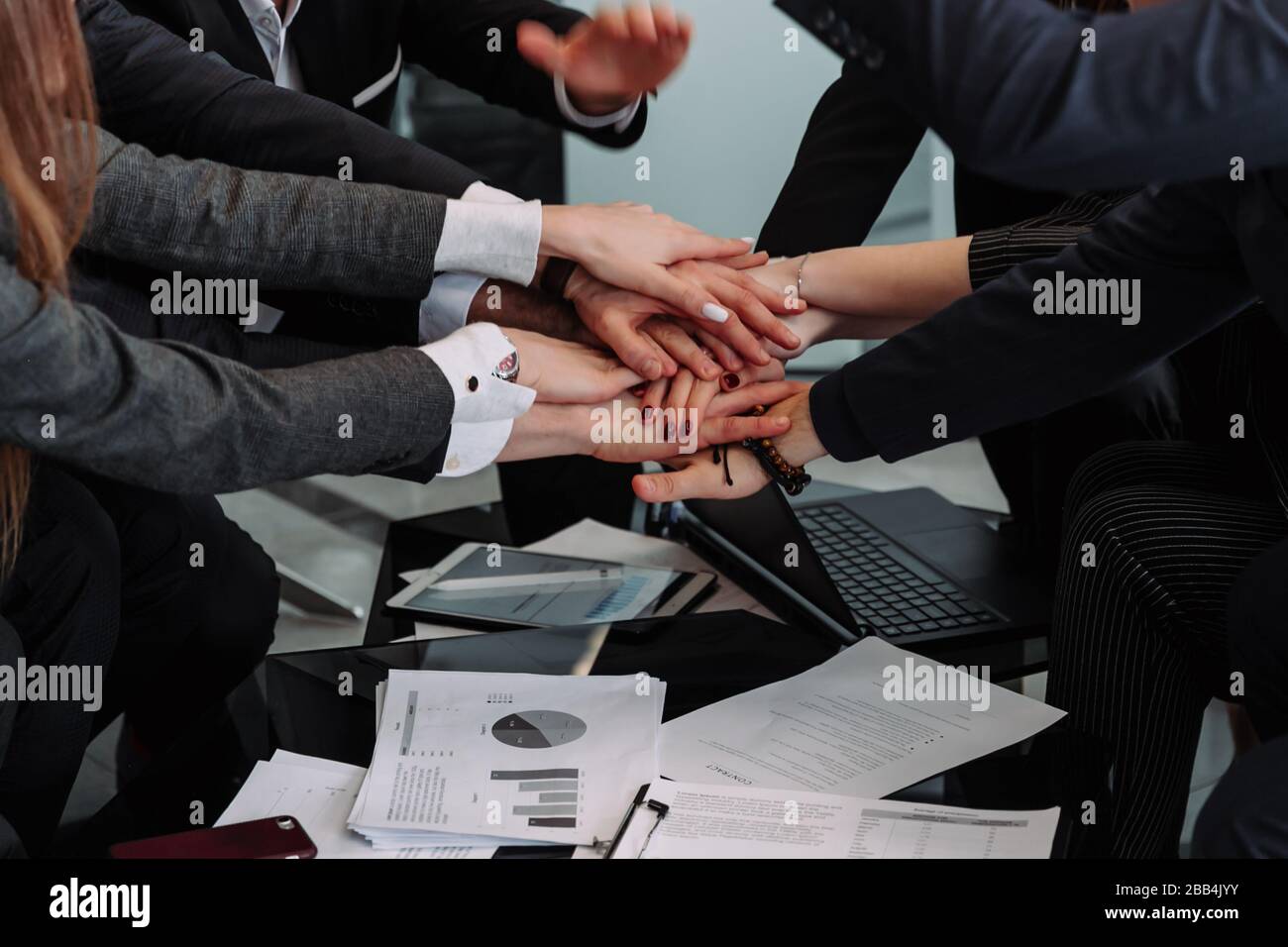 diverse workers or employees put hands in stack showing support and ...