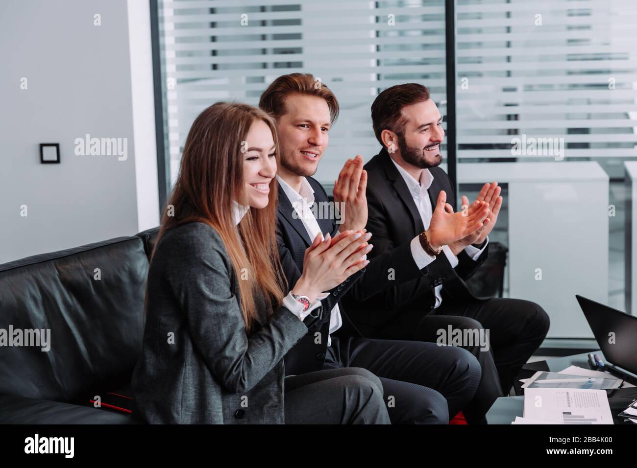 group of business people clapping hands to congratulate their boss ...