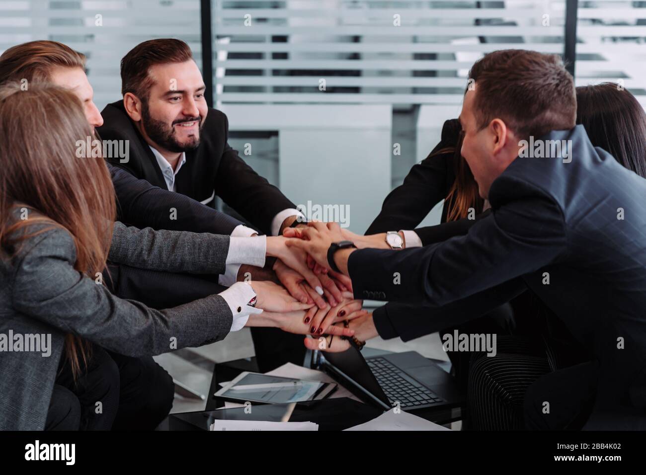 diverse workers or employees put hands in stack showing support and ...