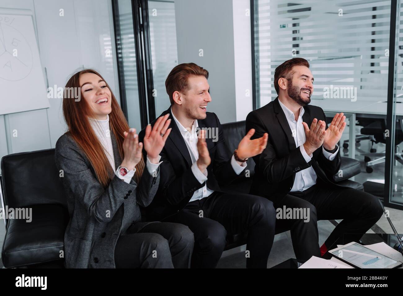 group of business people clapping hands to congratulate their boss ...