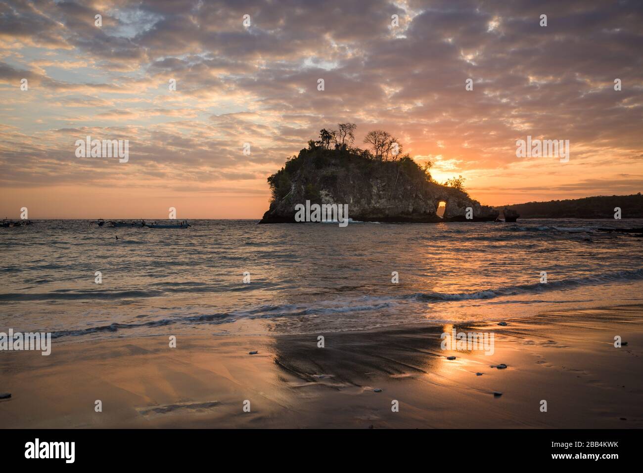 Crystal Bay at low tide with the sunset through the rock island, sea ...