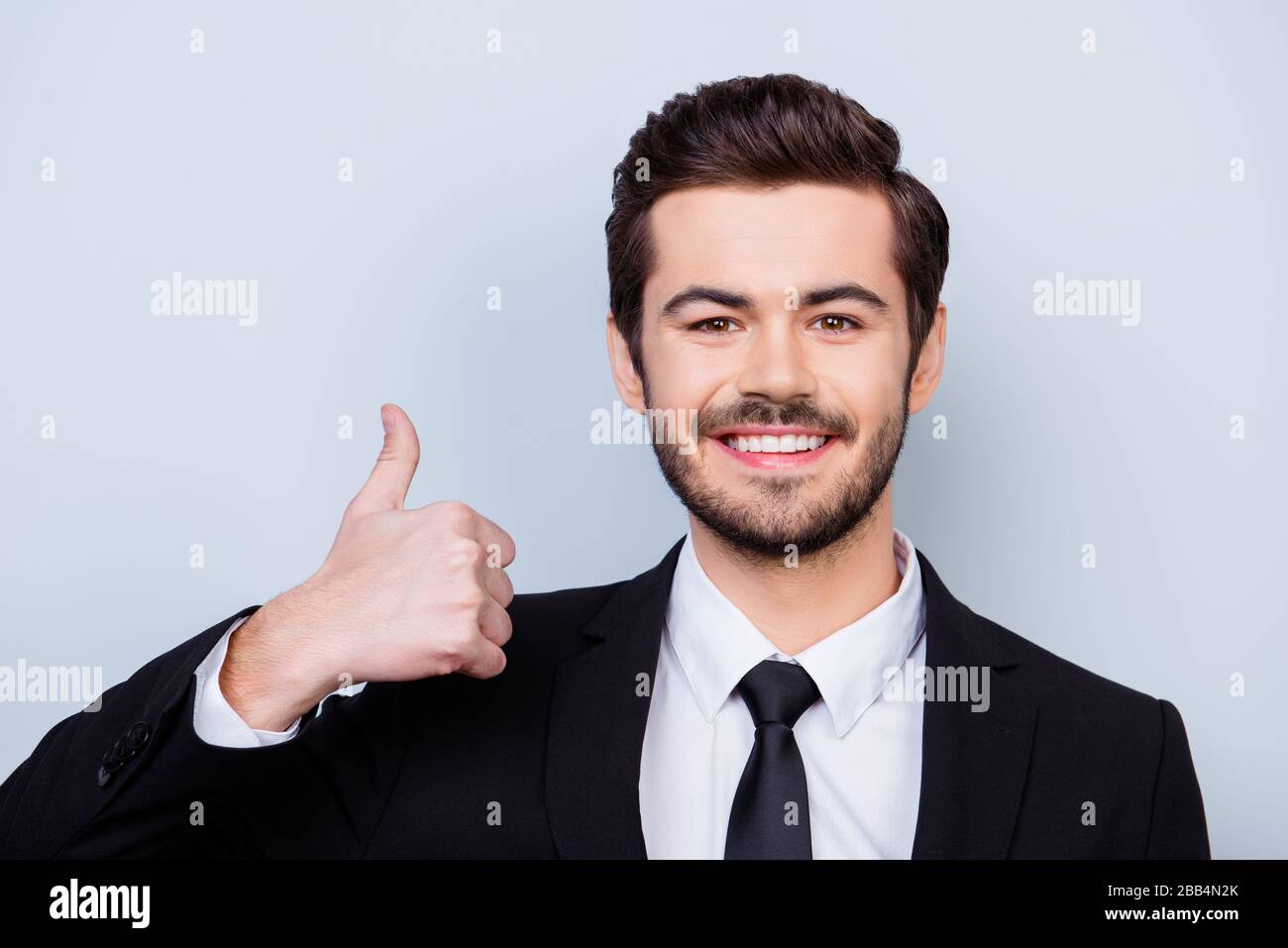 Close up photo of young smart man showing thumb up by recommending his ...