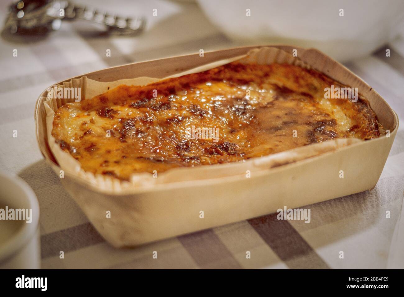Closeup high angle shot of a delicious lasagna in a container on a ...