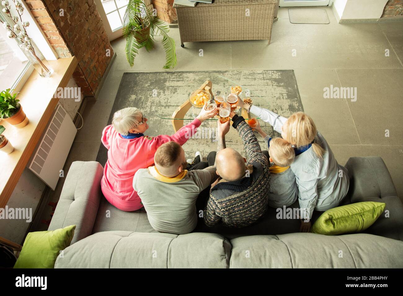 Excited family watching football, sport match at home. Grandparents ...