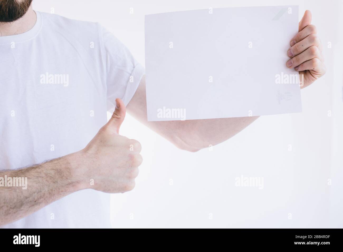 Bearded man holding a blank white sheet of paper. Angry young guy ...