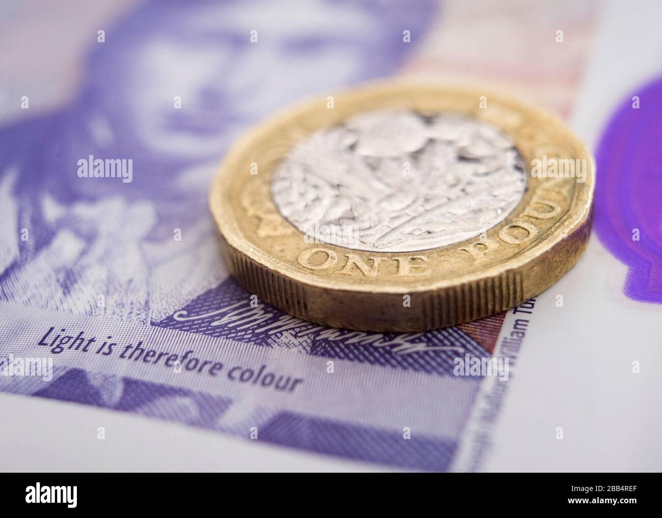 British currency a twenty pound note with a one pound coin Stock Photo ...