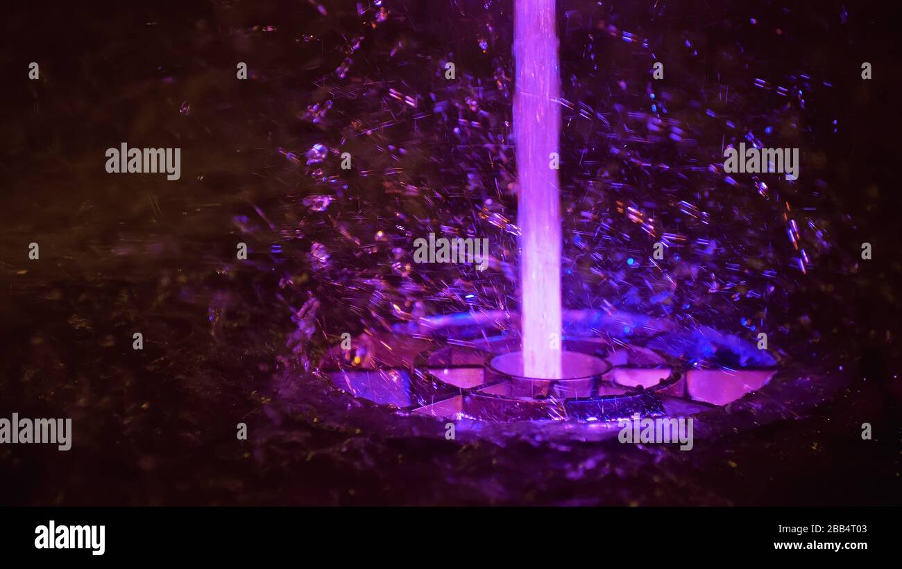 Splashes of colorful fountain. Water illuminated in diverse colors ...