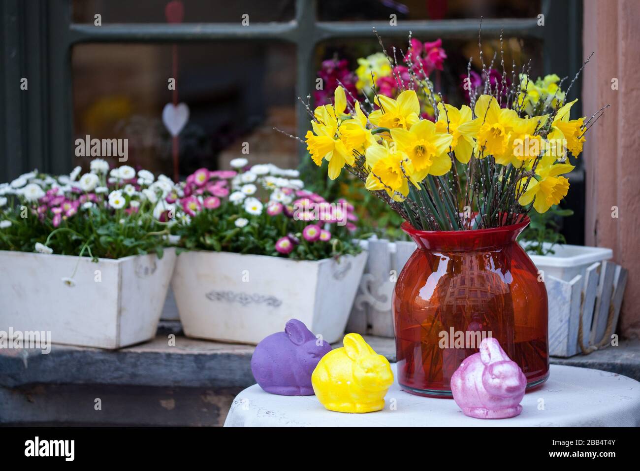 Easter still life composition with bunnies figurines and yellow flowers ...