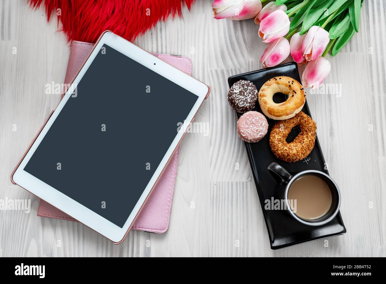 Tablet on a nice decorated white wooden table background. Styled design ...