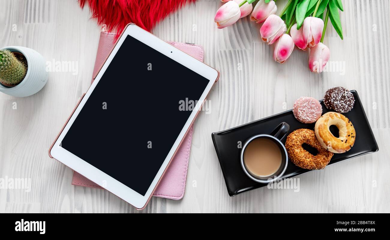 Tablet on a nice decorated white wooden table background. Styled design ...