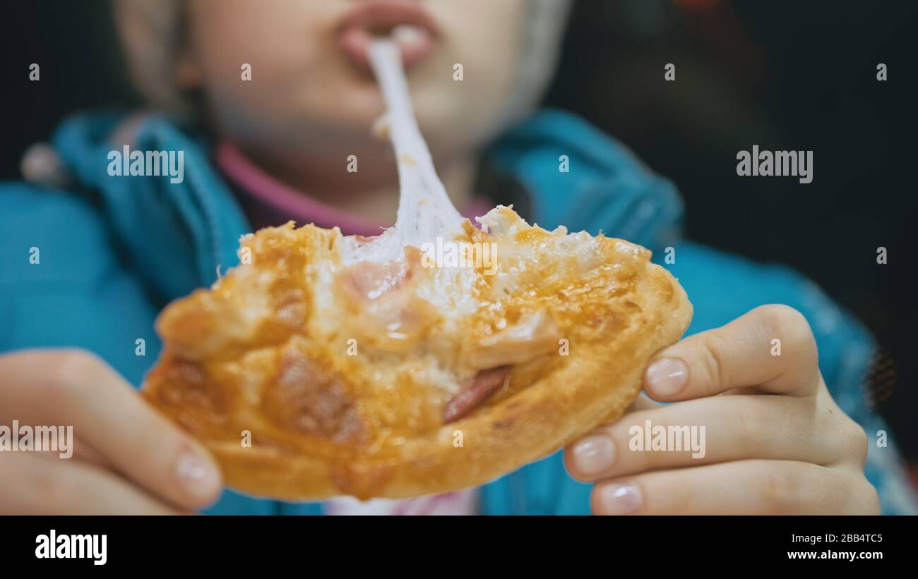 Child eat pizza cheese four. Close up of young girl woman eating pizza ...