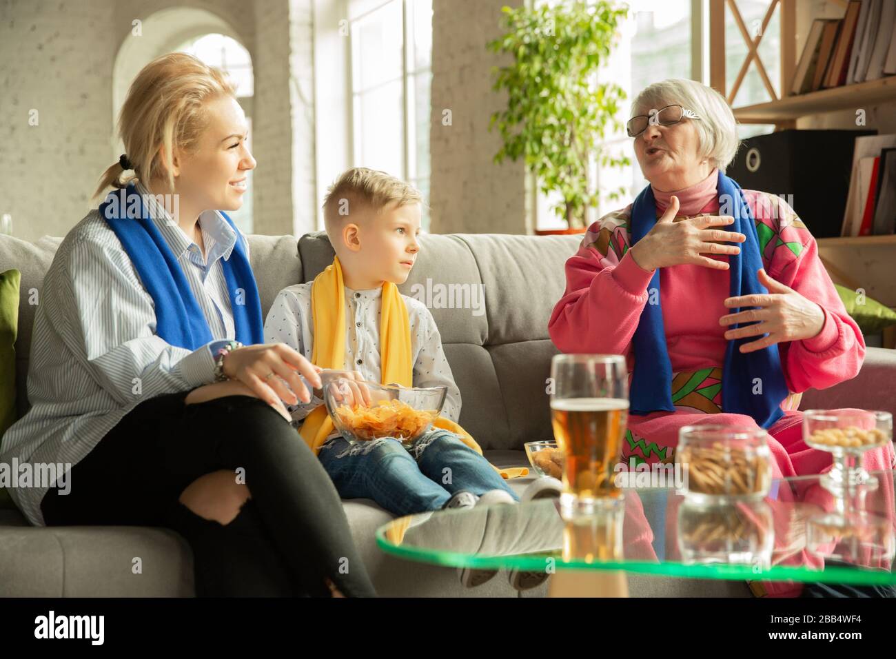 Excited family watching football, sport match at home. Grandma, mother ...