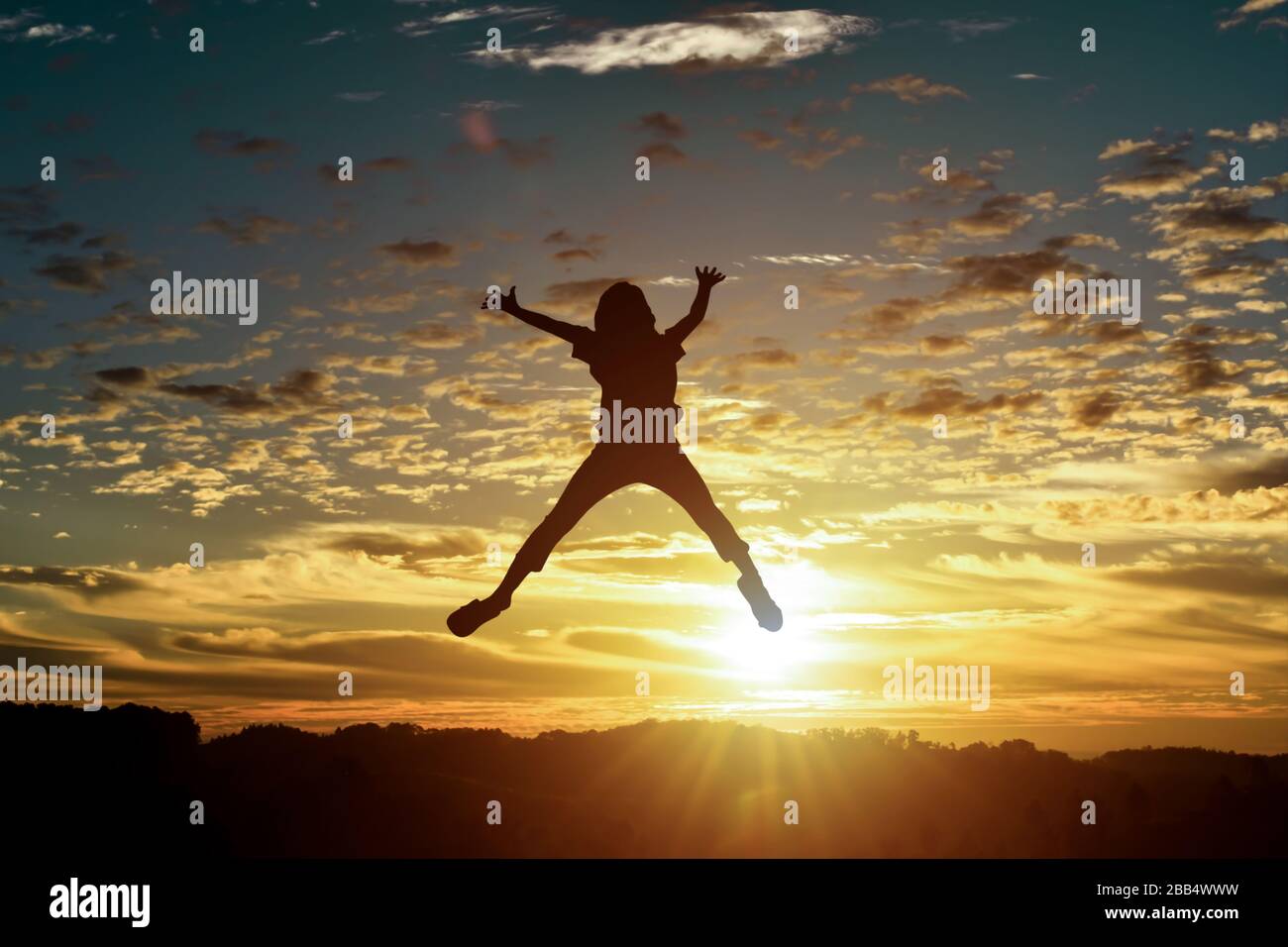 Silhouette of young woman jumping at sunset background Stock Photo - Alamy