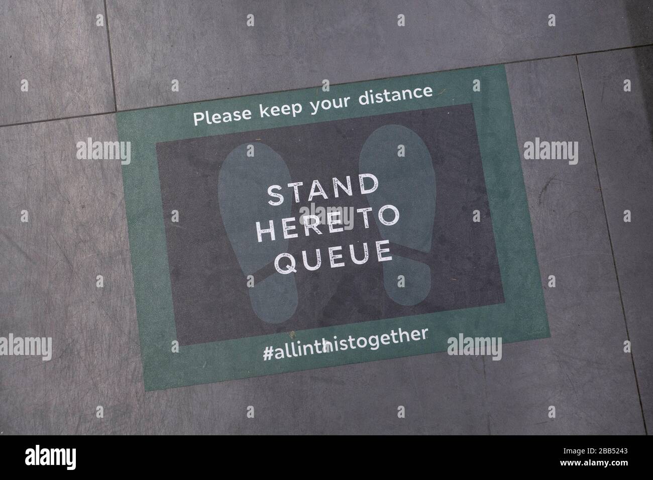Streatham, UK. 30th Mar, 2020. Stand Here To Queue signs on the floor ...