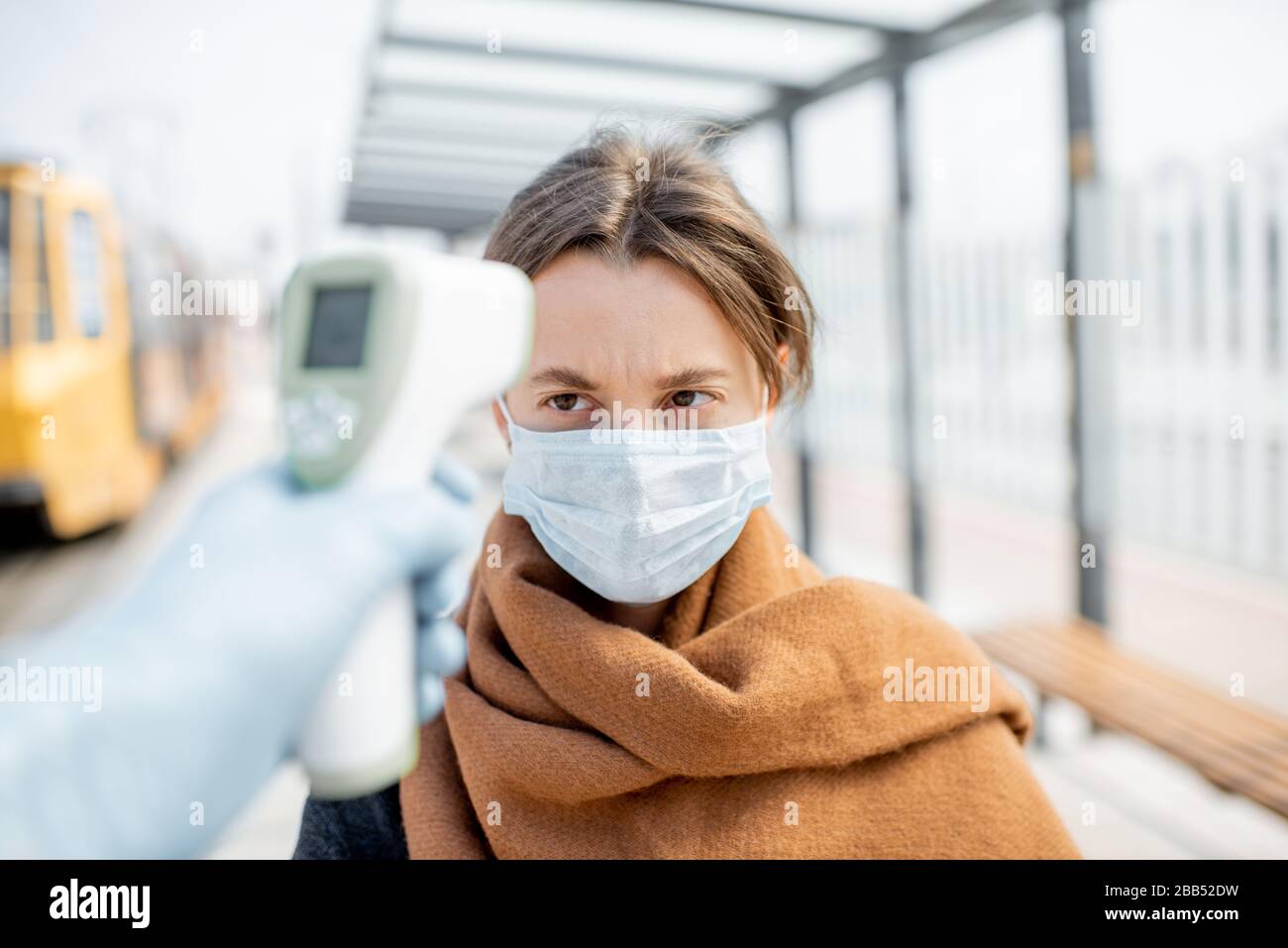 Measuring temperature with infrared thermometer of a young woman in ...