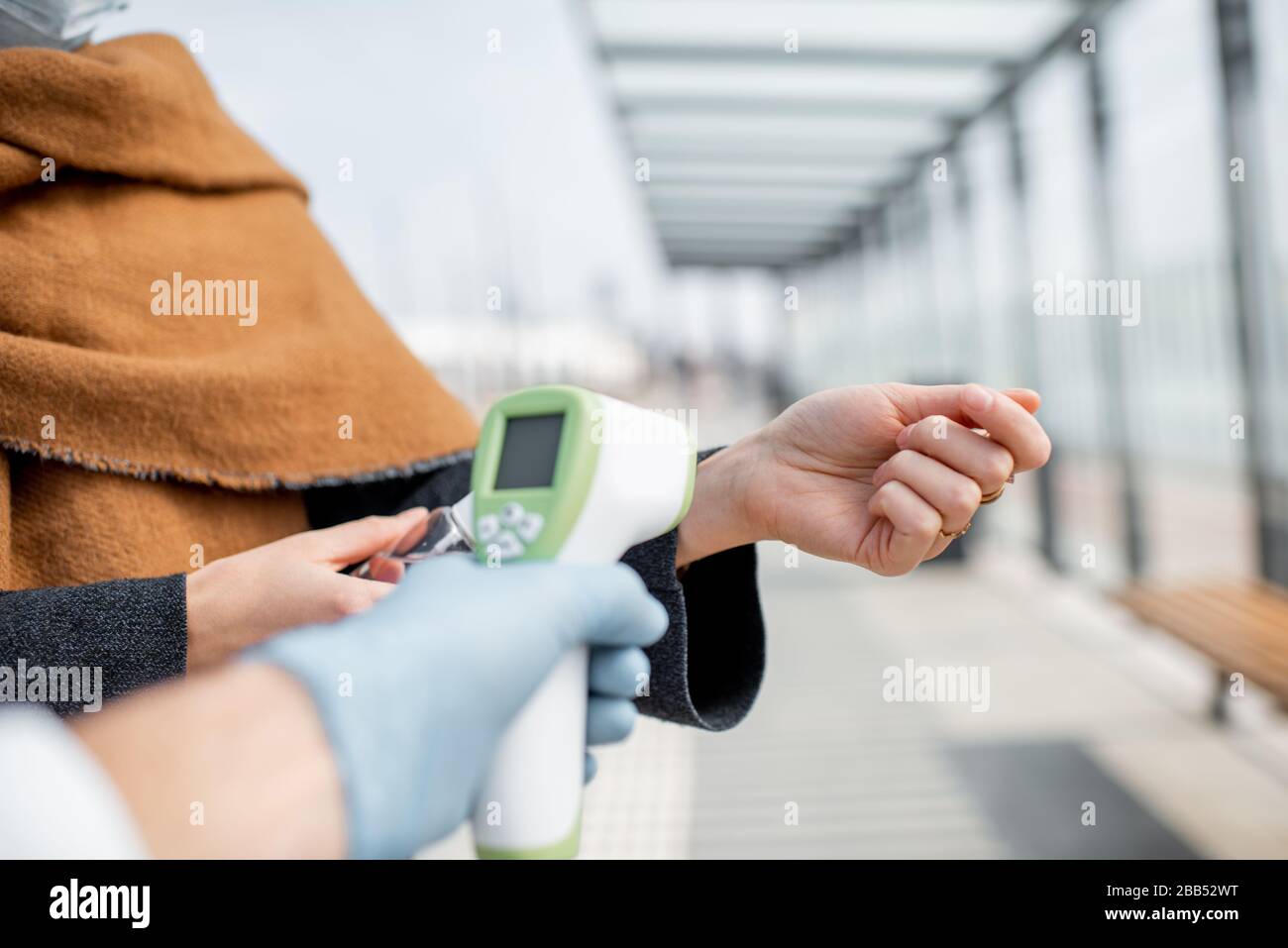 Measuring body temperature with infrared thermometer at a checkpoint ...
