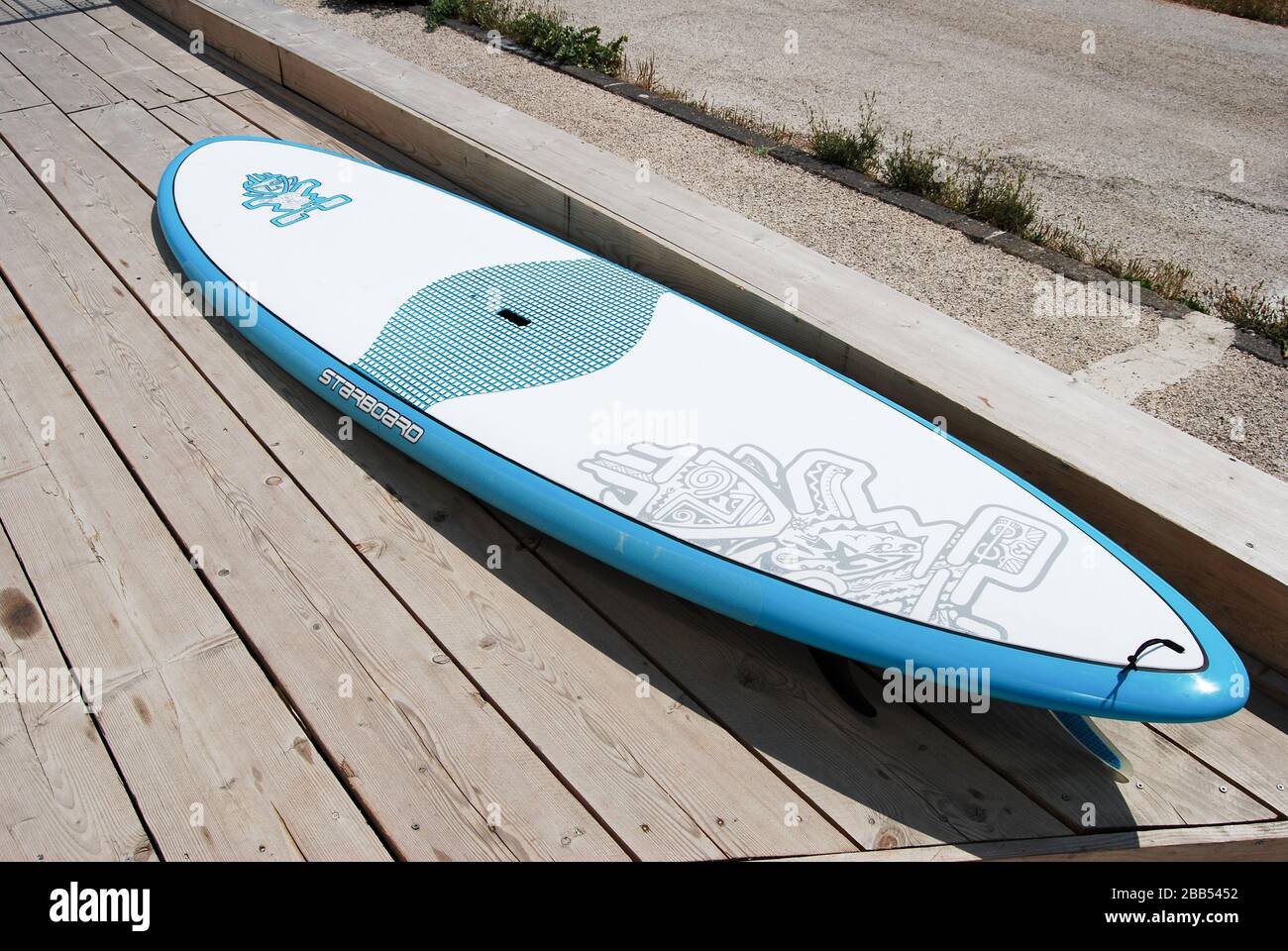 Blue and white surf board «Starboard» next to the beach Stock Photo - Alamy