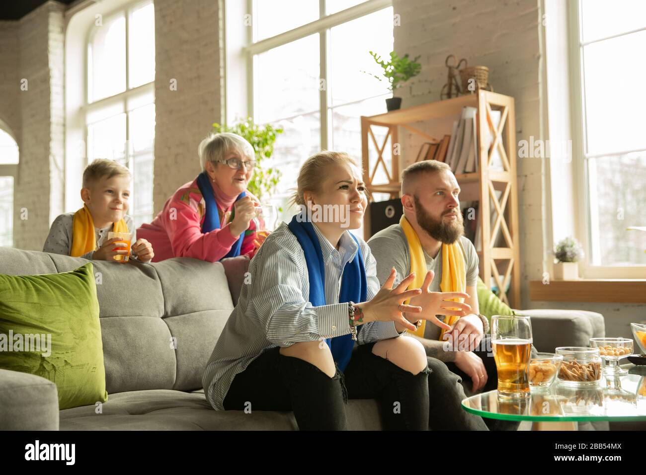 Excited family watching football, sport match at home. Grandparents ...