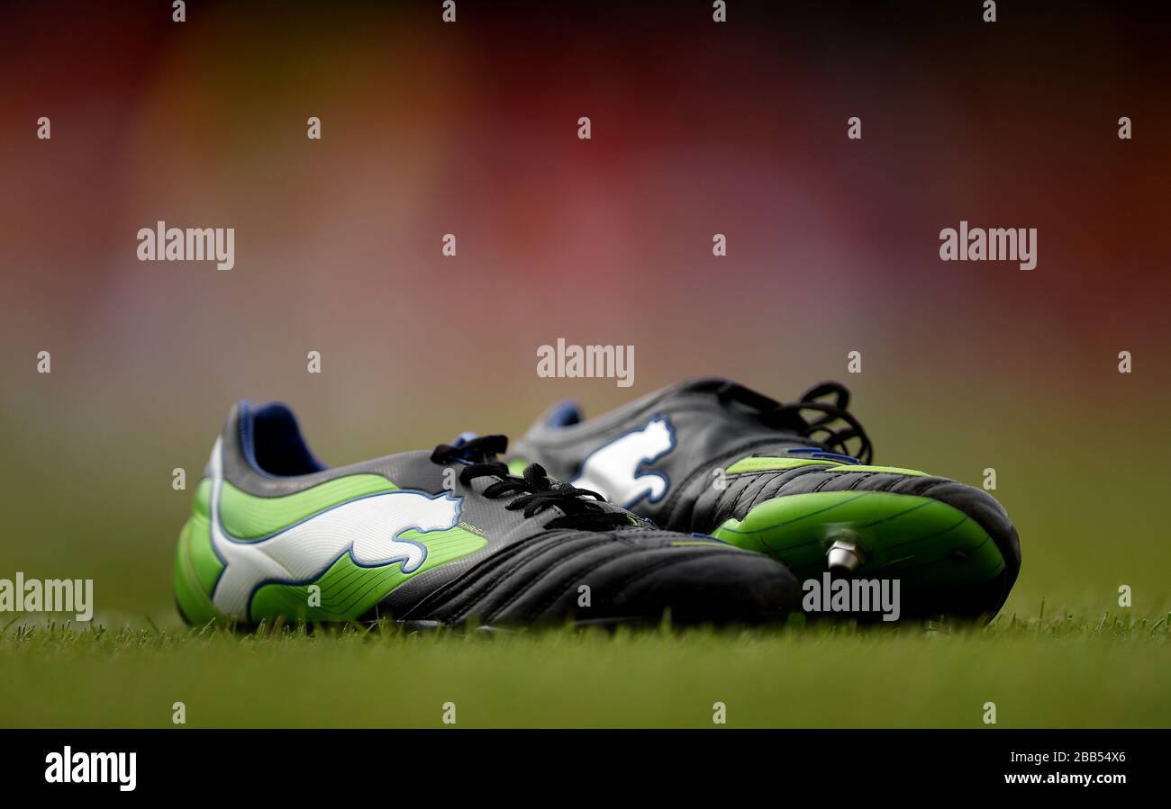 General view of a pair of Puma football boots on the side of the pitch ...