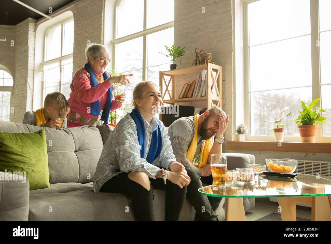 Excited family watching football, sport match at home. Grandparents ...