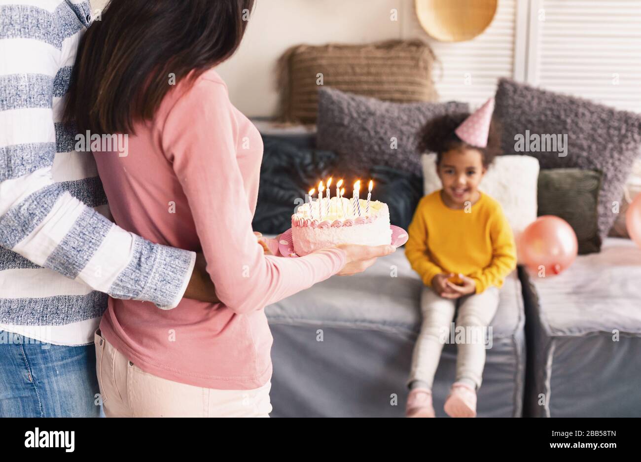 Birthday of little girl. Parents give cake Stock Photo - Alamy
