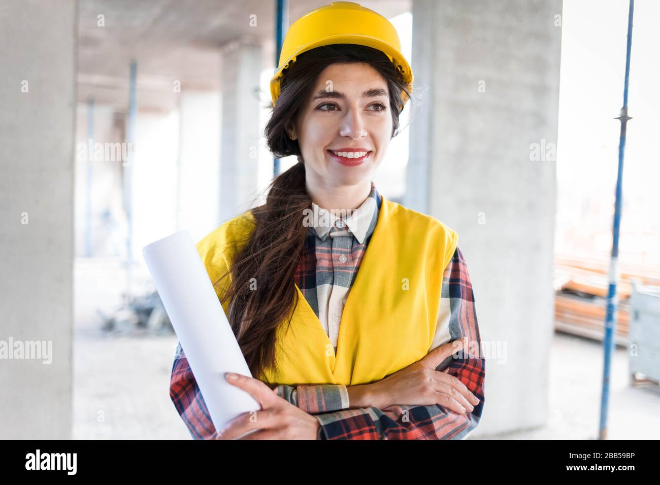 Positive smile woman engineer builder stands at a construction site ...