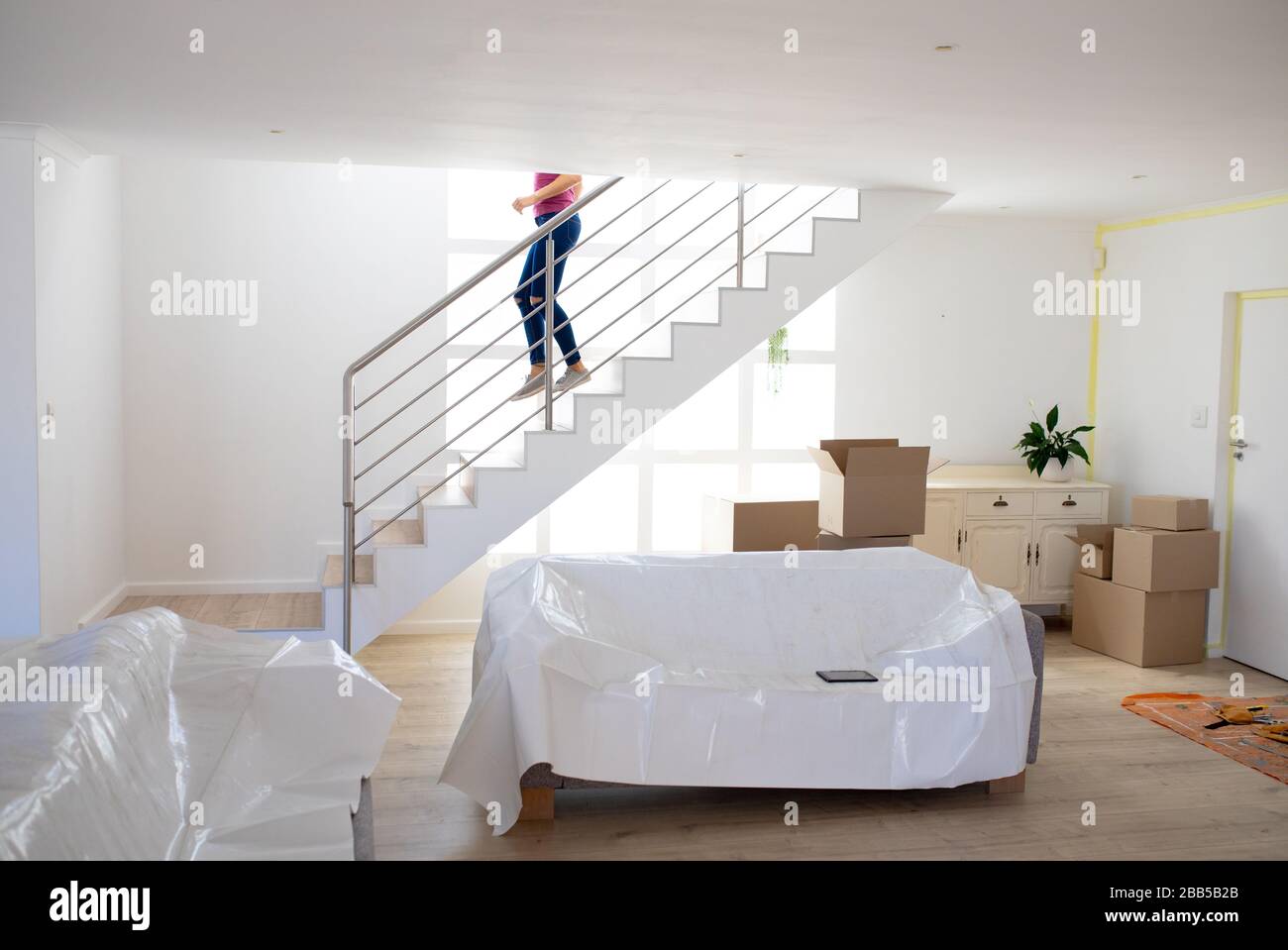 Woman descending stairs hi-res stock photography and images - Alamy