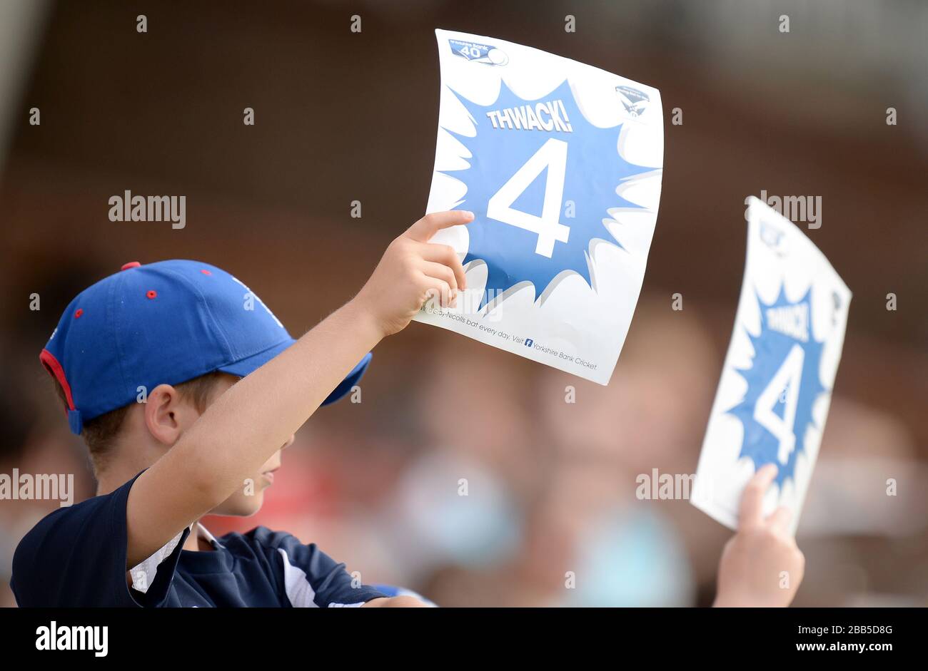 A young cricket fans holds up a 4 sign Stock Photo - Alamy