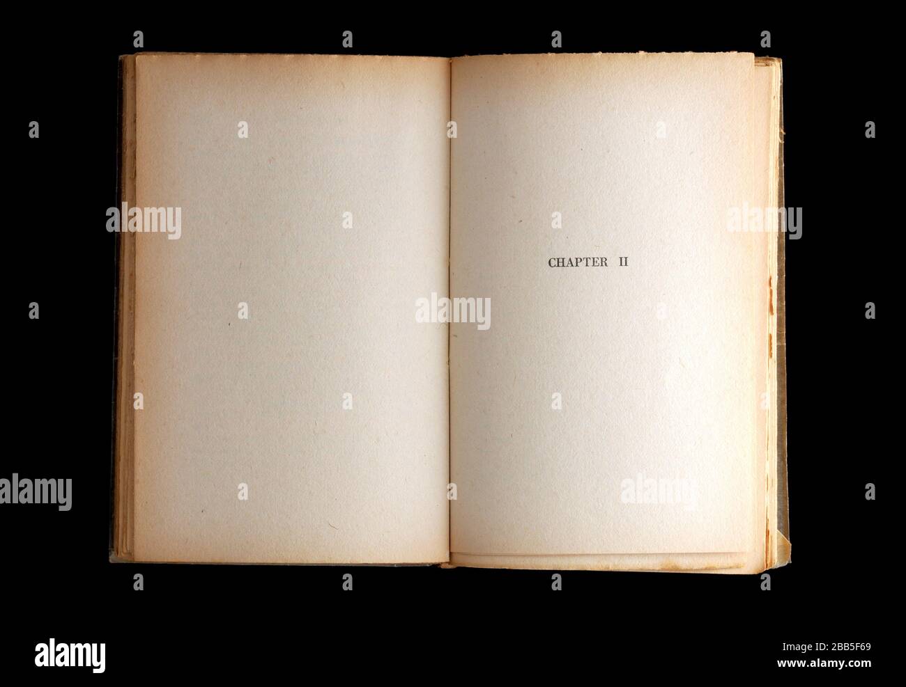 Close-up view at old book. Paper texture, chapter II text on empty page ...