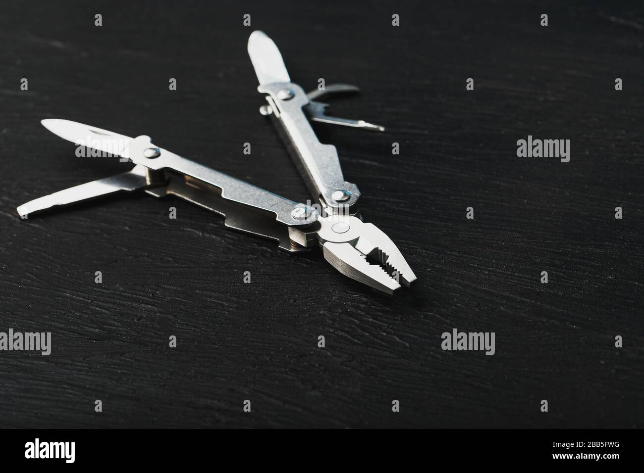 Multitool is a multi-functional tool on a black background. The concept ...