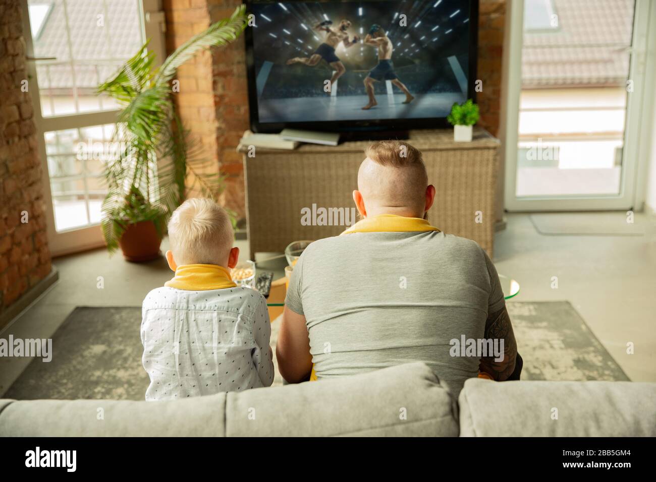 Excited family watching martial arts championship, sport match at home ...