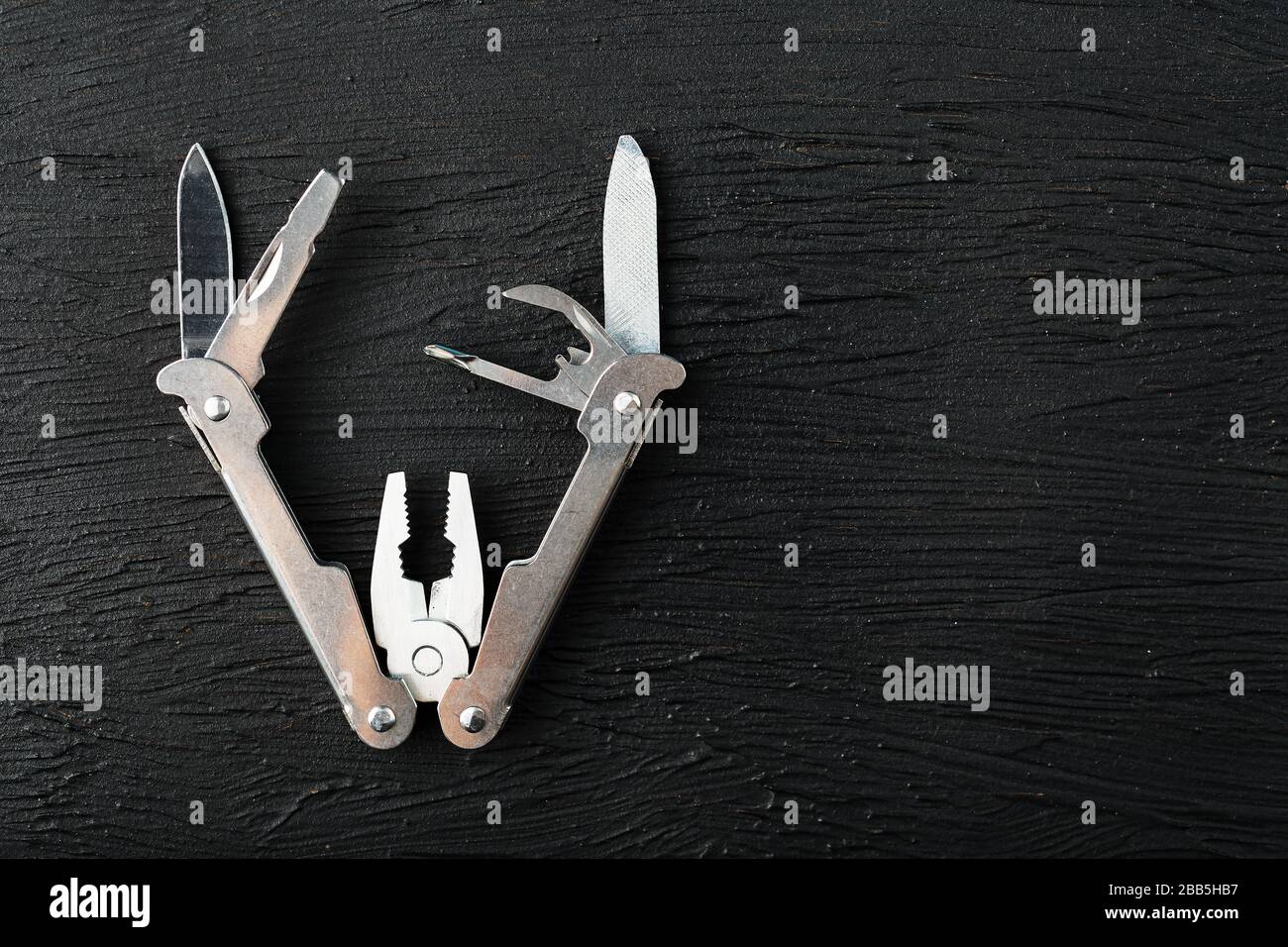 Multitool is a multi-functional tool on a black background. The concept ...